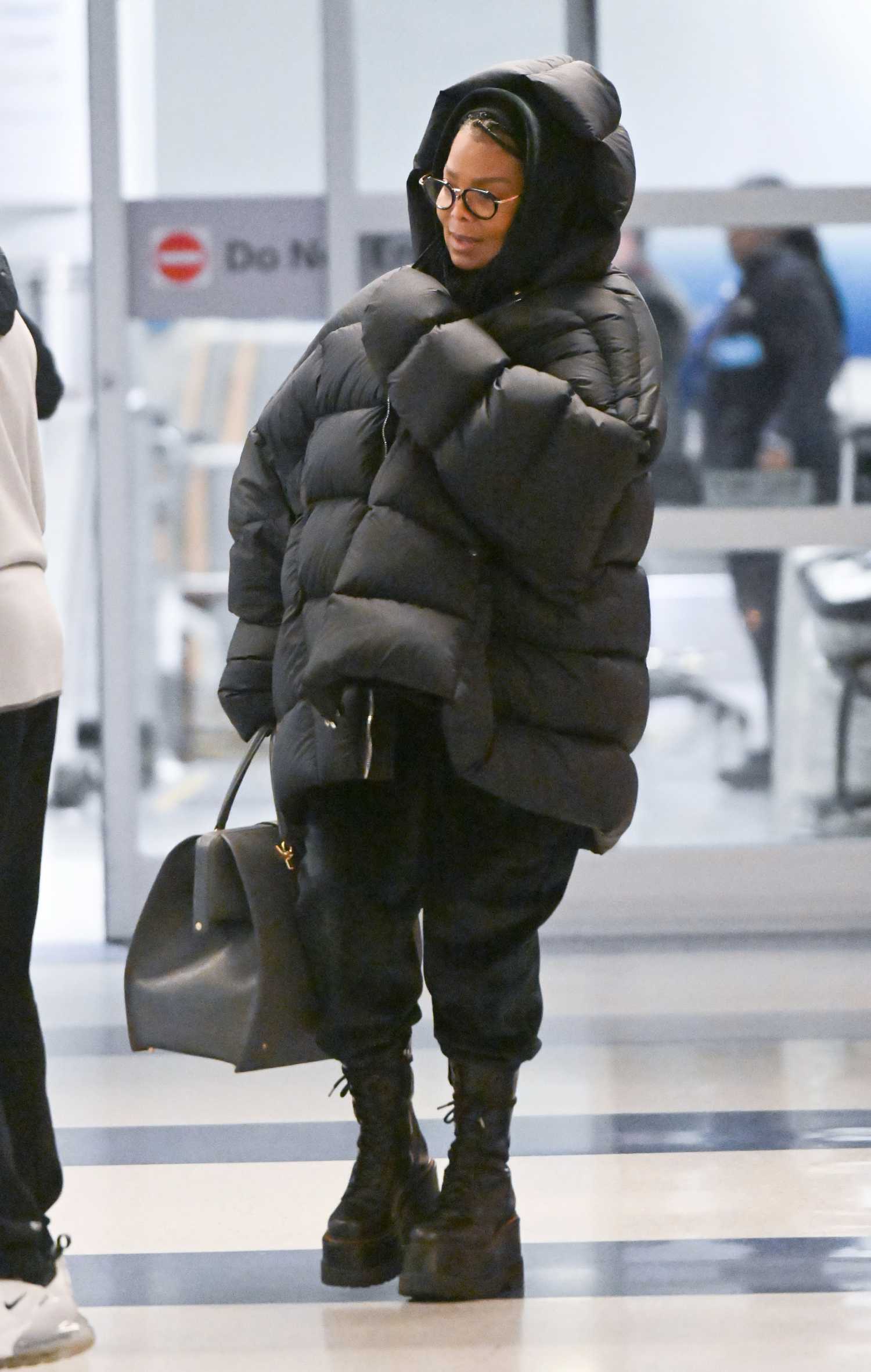 Janet Jackson in a Black Oversized Puffer Jacket Arrives at JFK Airport ...